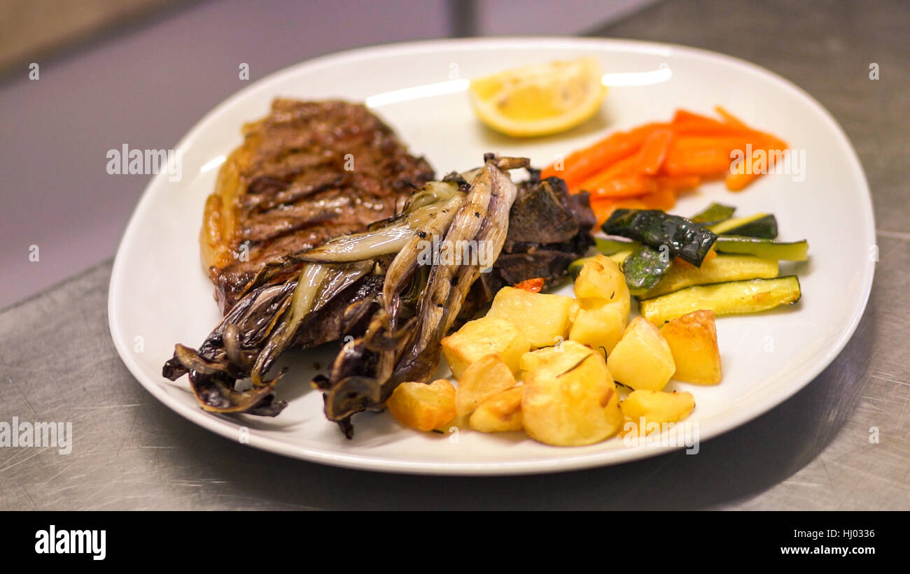 Preparing a dish of meat in the kitchen of a restaurant Stock Photo - Alamy