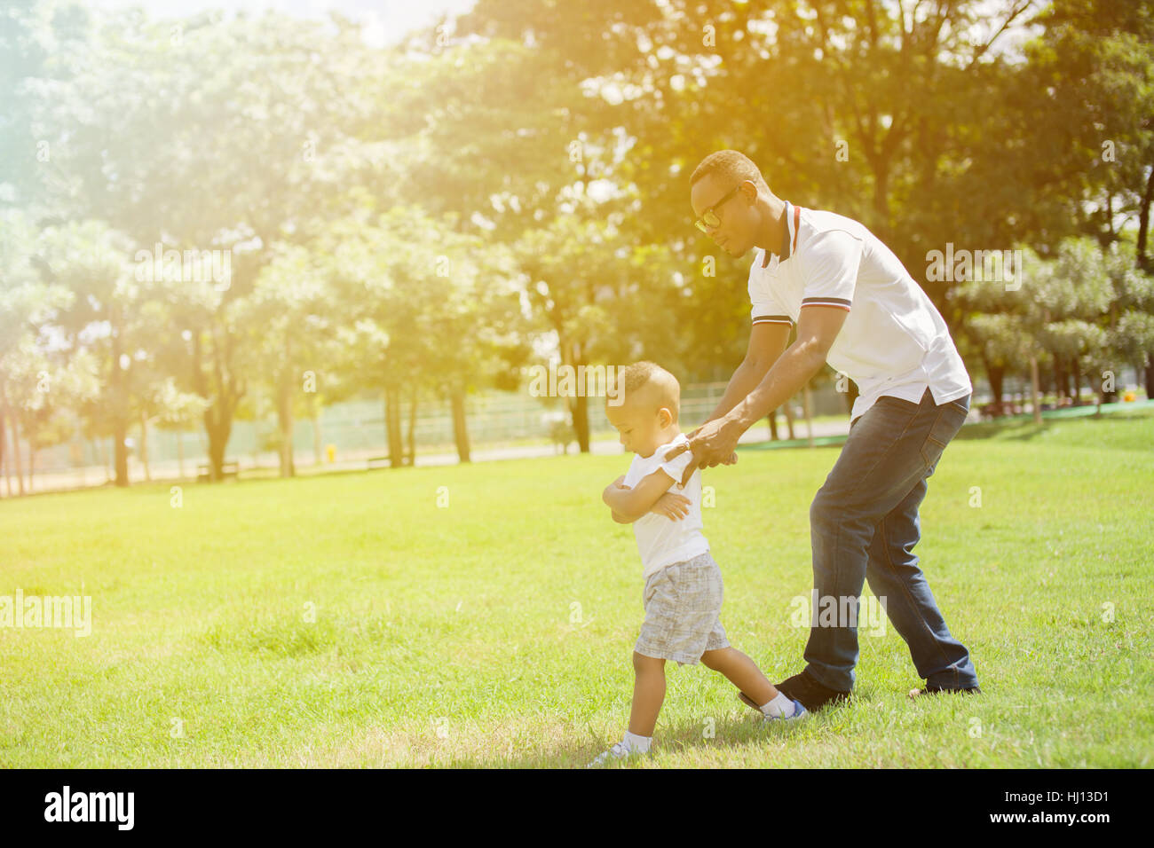 Father and son running and chasing each other in green park Stock Photo ...