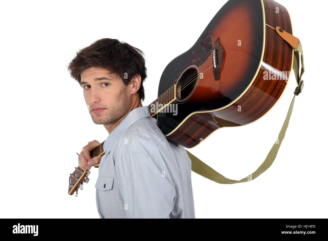 young man carrying a guitar on his shoulder Stock Photo - Alamy