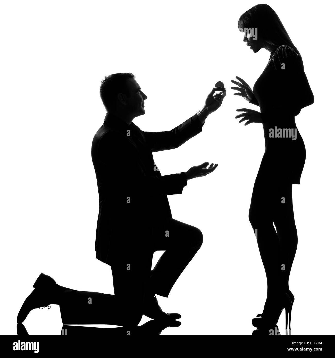 one caucasian couple man kneeling offering engagement ring and woman ...