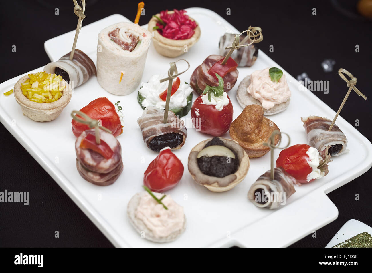 types of canapes for cocktails on a white plate, note shallow depth of ...