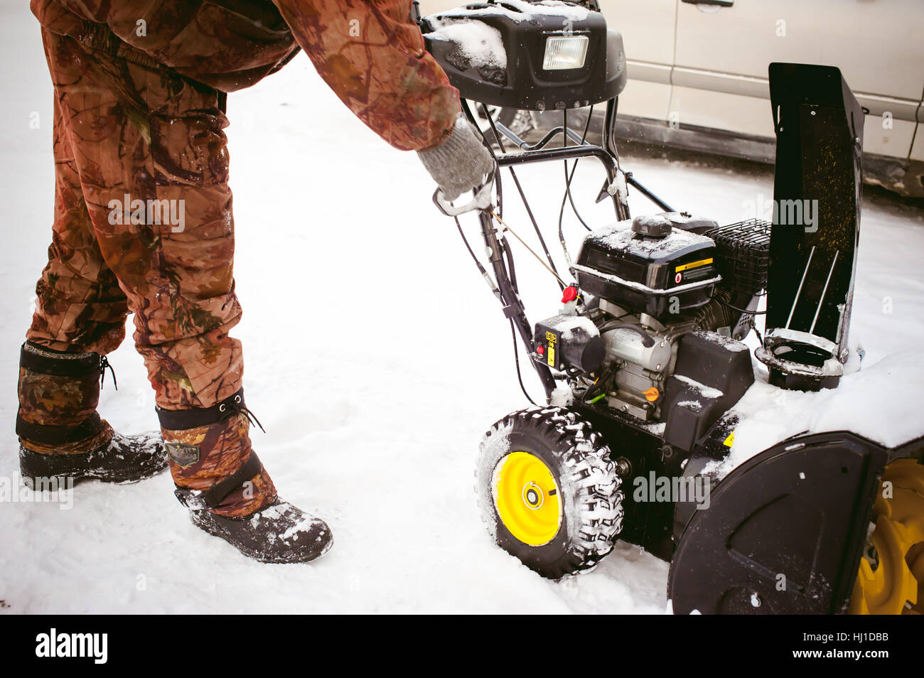 man starts the engine snow blower Stock Photo - Alamy