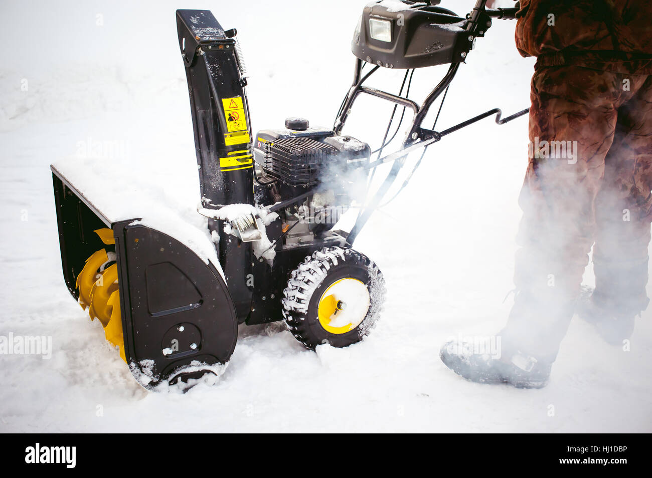 man starts the engine snow blower Stock Photo - Alamy