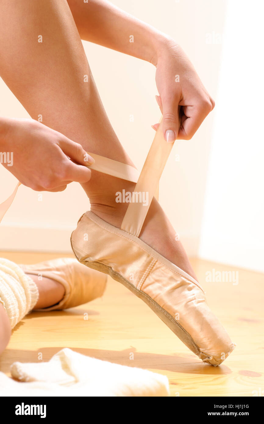 Ballerina tying ballet slippers hi-res stock photography and images - Alamy