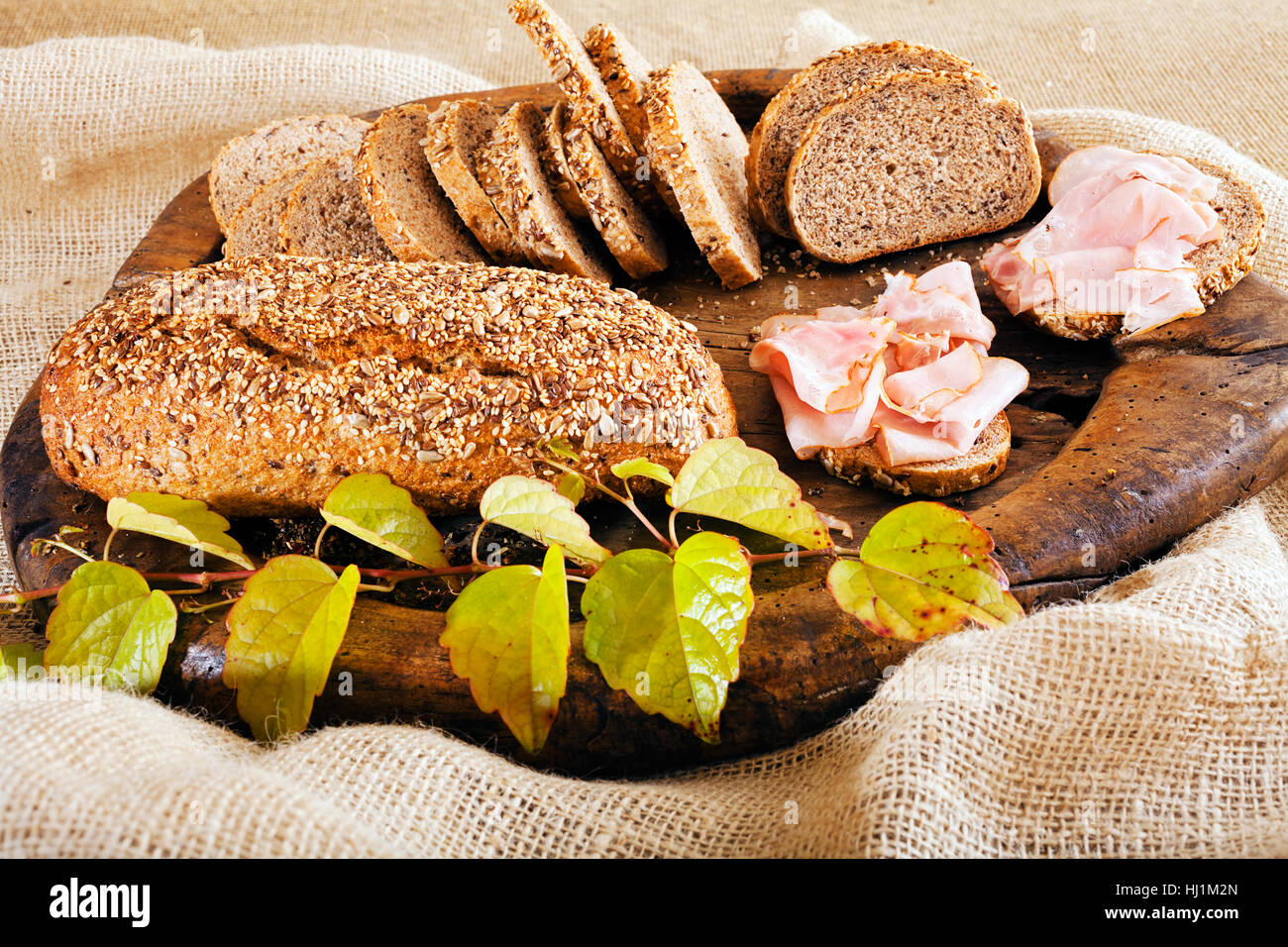 integral bread on the wood board with ham and green branch, note ...