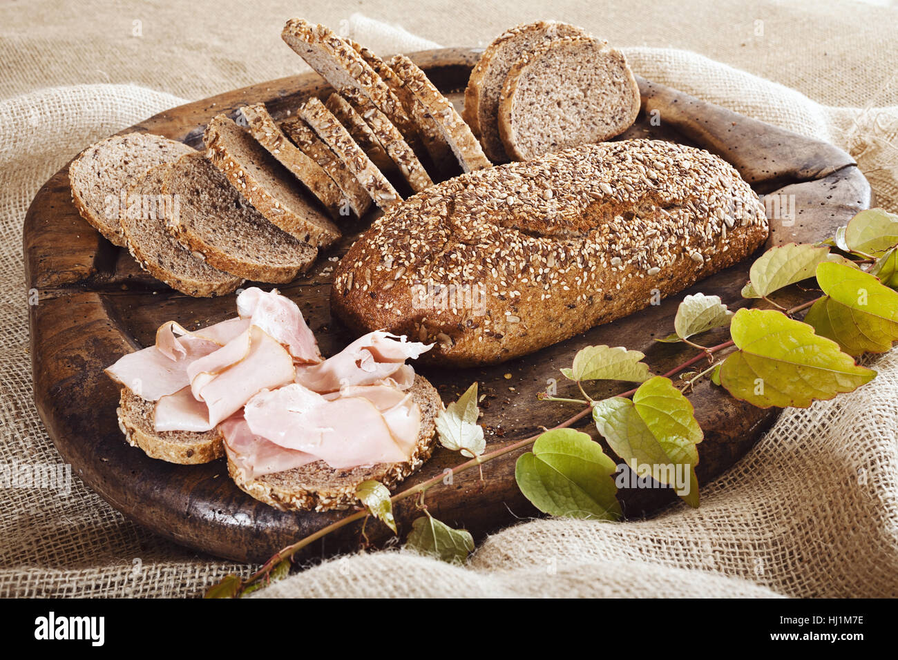 integral bread on the wood board with ham and green branch, note ...