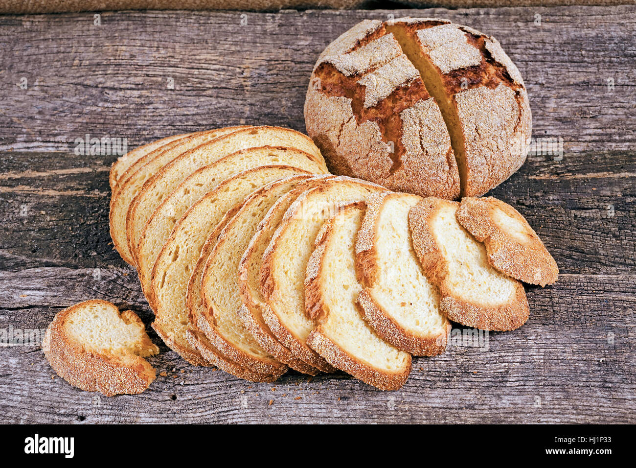 Round corn bread and slices of corn bread on the wooden board, note ...