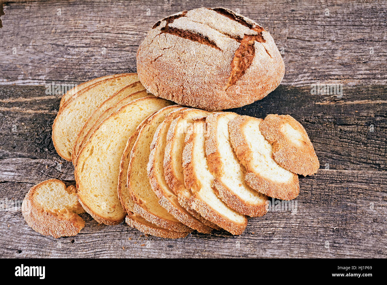 Round corn bread and slices of corn bread on the wooden board, note ...