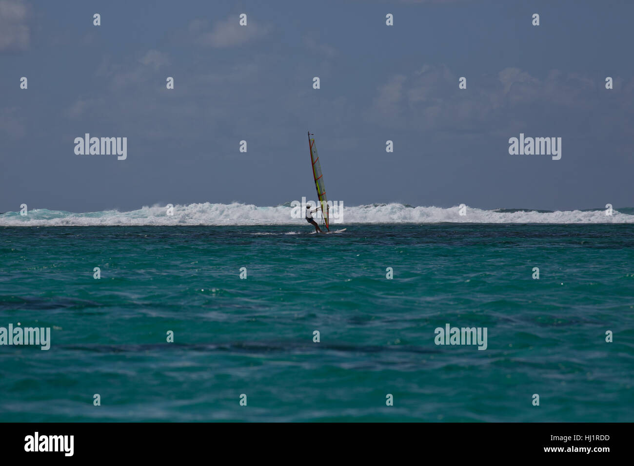 Windsurfer approaching a line of coral reef breakers Stock Photo - Alamy