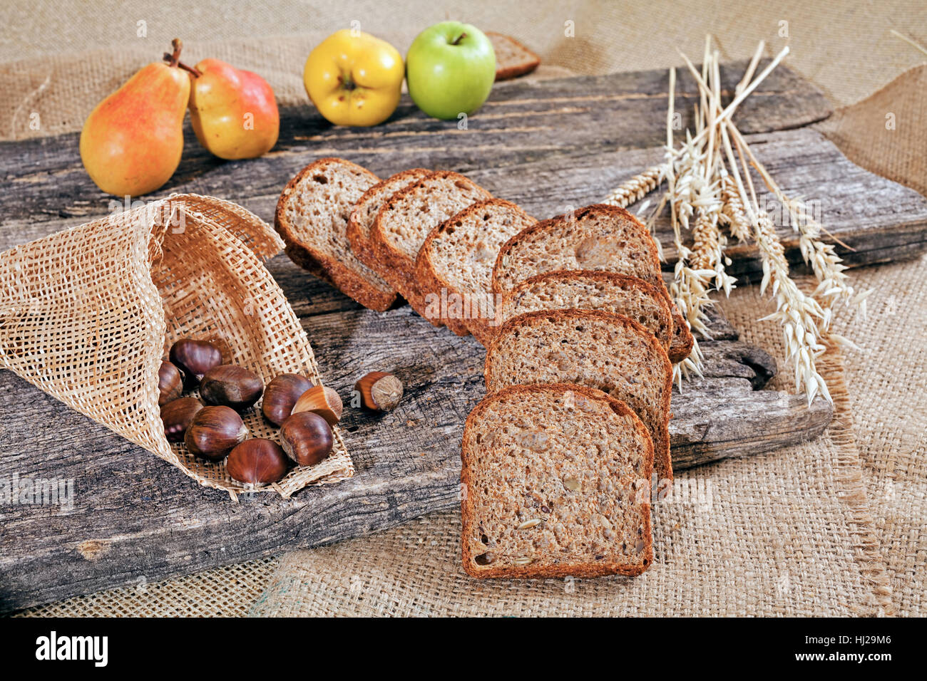 Decoration with rye bread on a wooden board with chestnuts in a cone ...