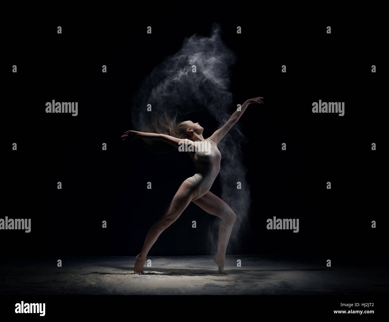 Athletic dancer in cloud of powder on the scene Stock Photo - Alamy