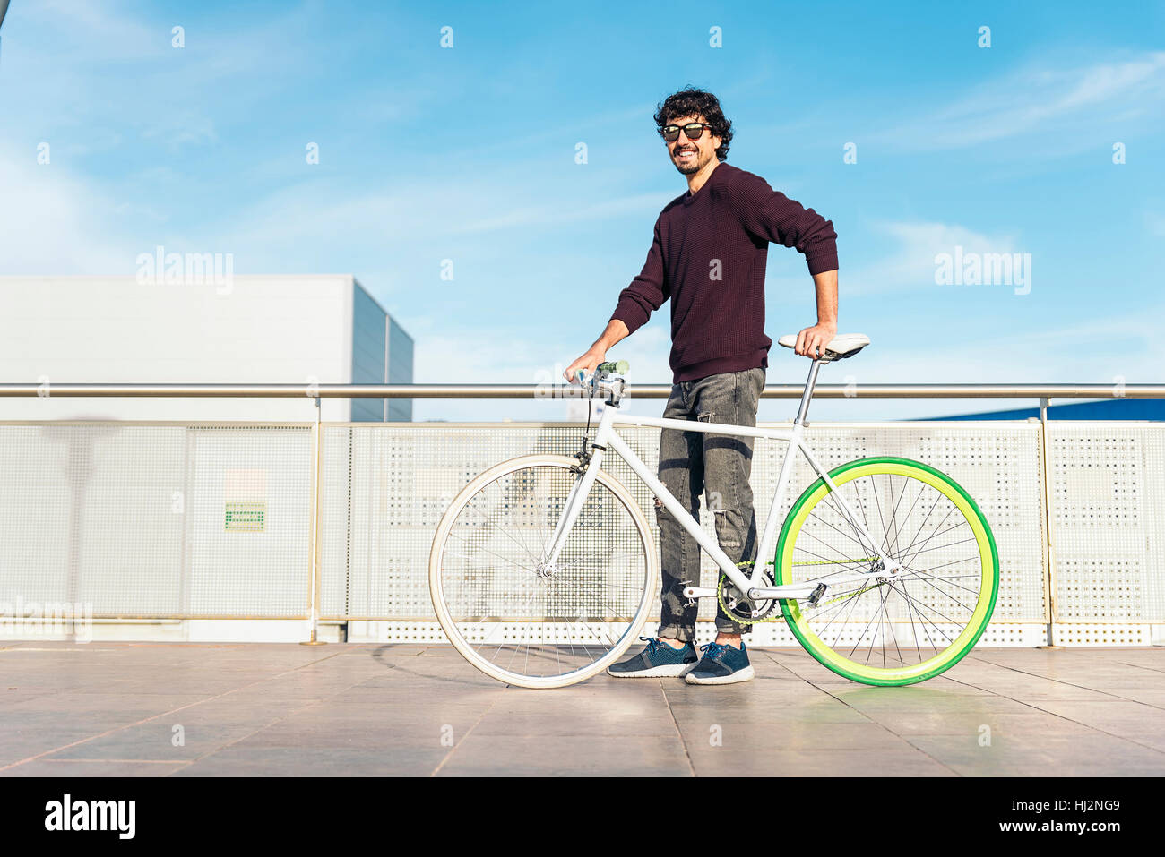 Outdoor portrait of handsome young man with fixed gear bicycle in the ...