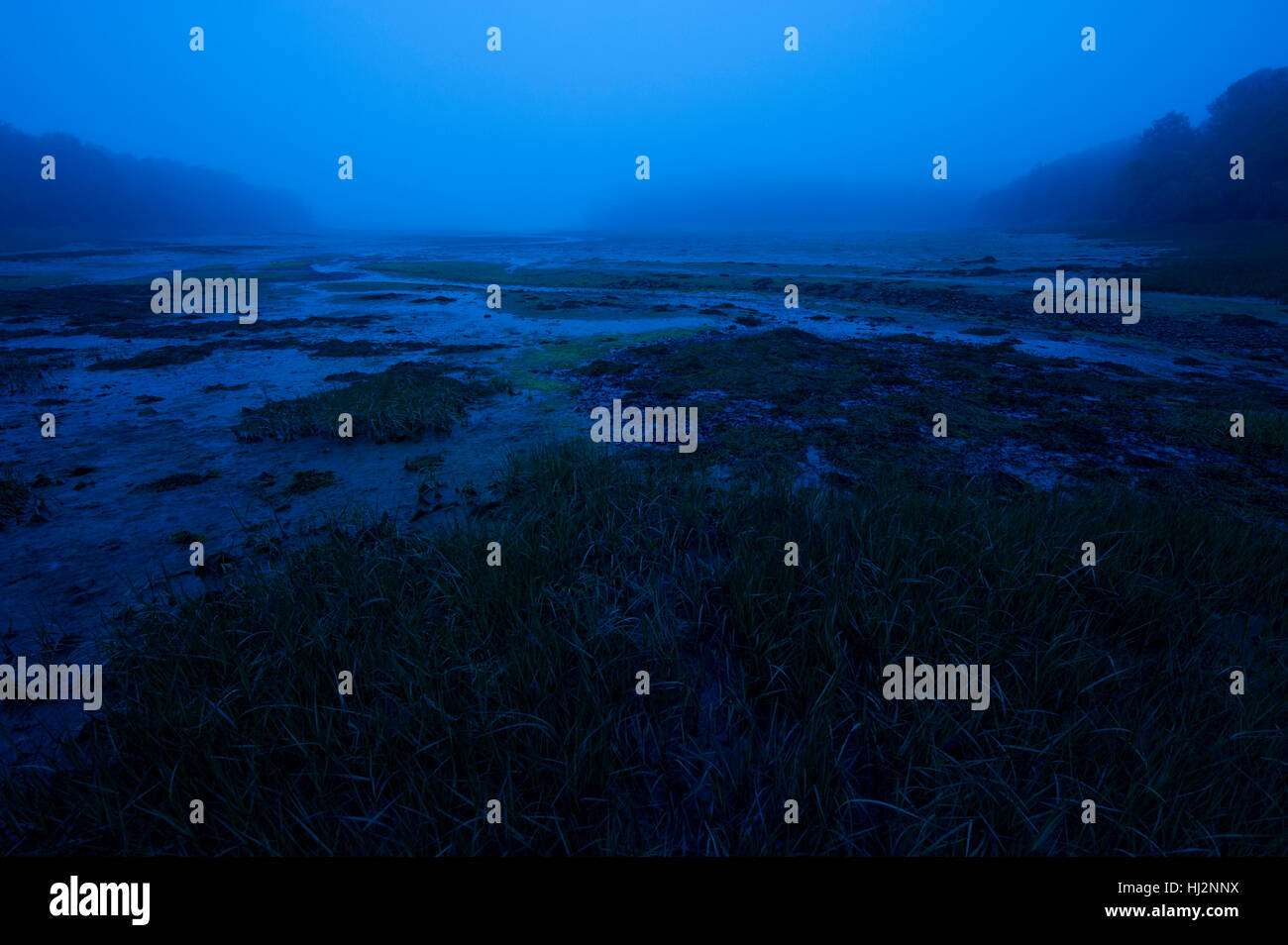 A blue scene of an empty bay at low tide photographed a dusk Stock ...