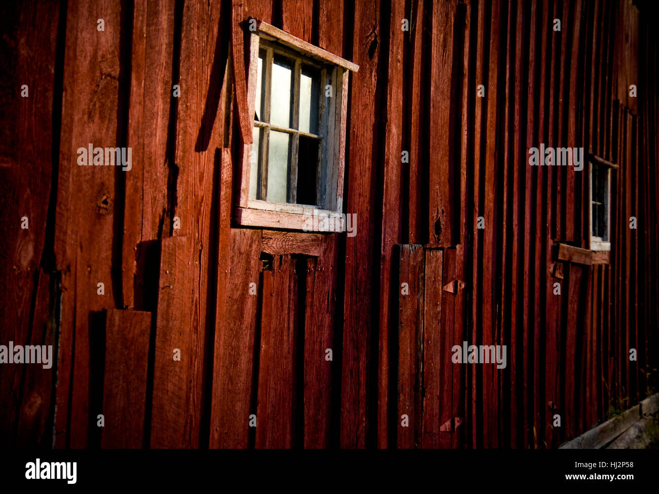 An old red barn window with a spotlight of sun Stock Photo - Alamy