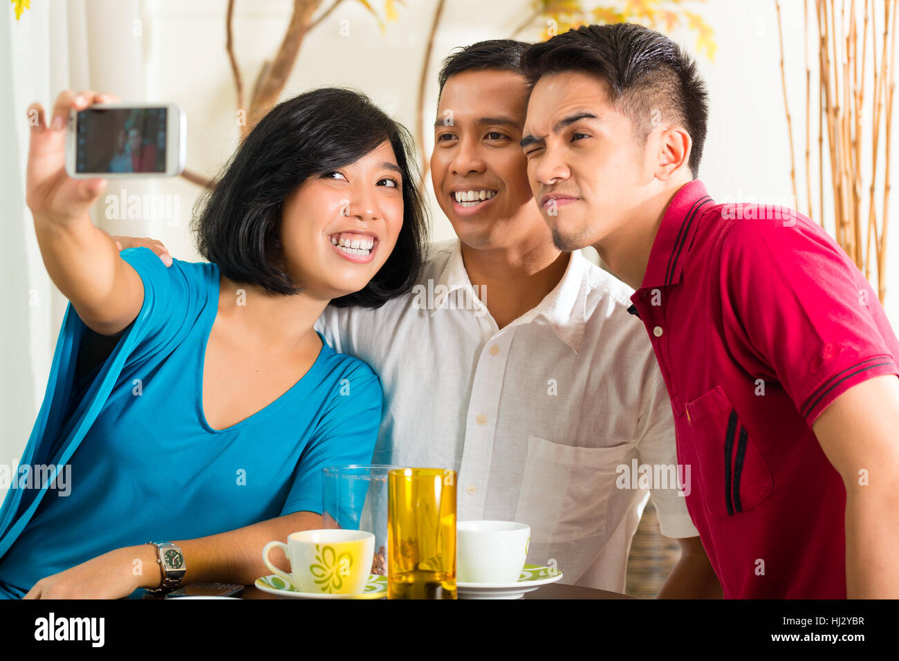 asian friends take picture with cell phone Stock Photo - Alamy