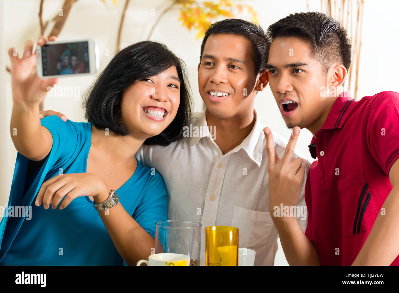 asian friends take picture with cell phone Stock Photo - Alamy