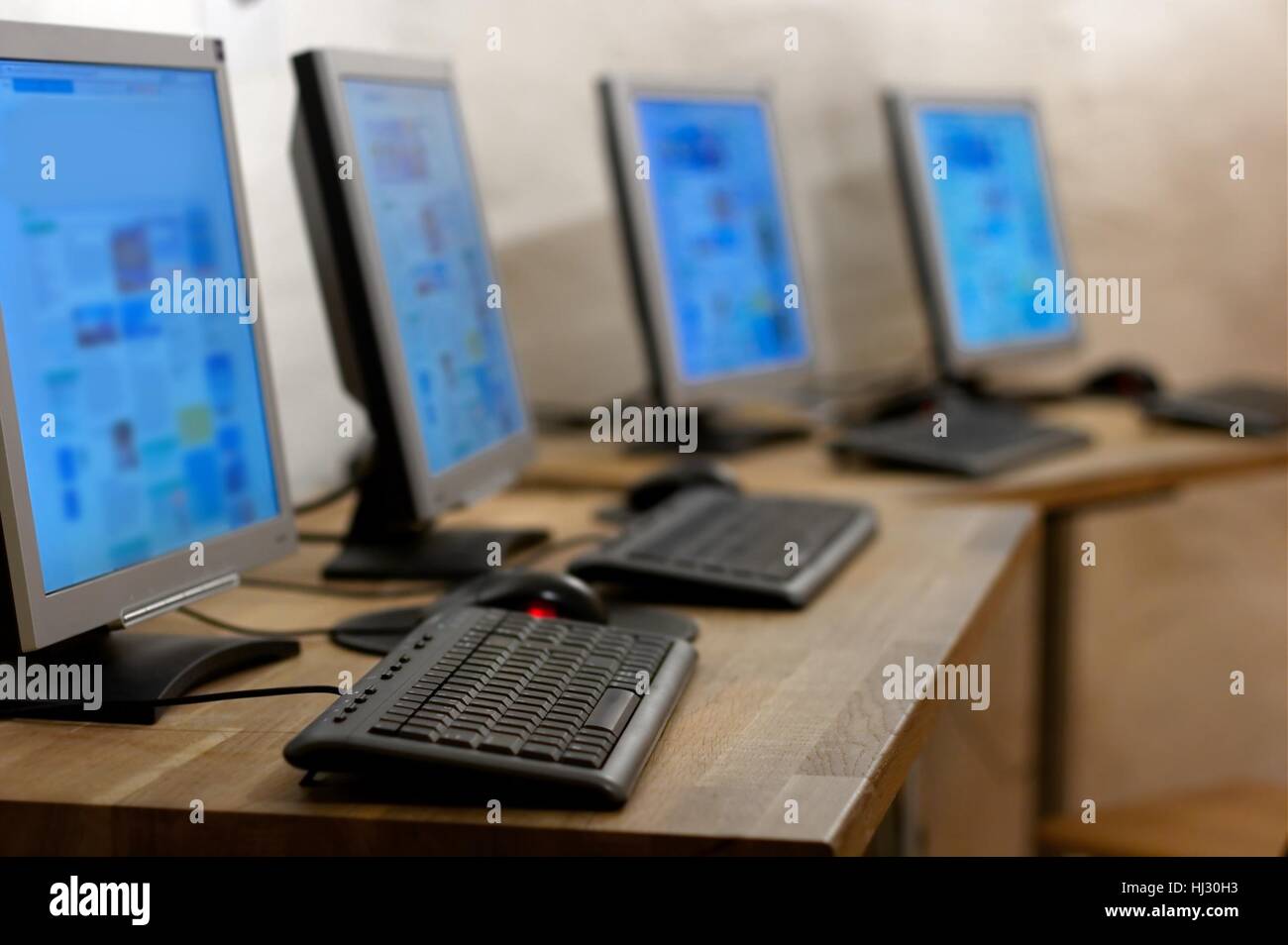 Four computer in a row in an office or internet cafe Stock Photo - Alamy