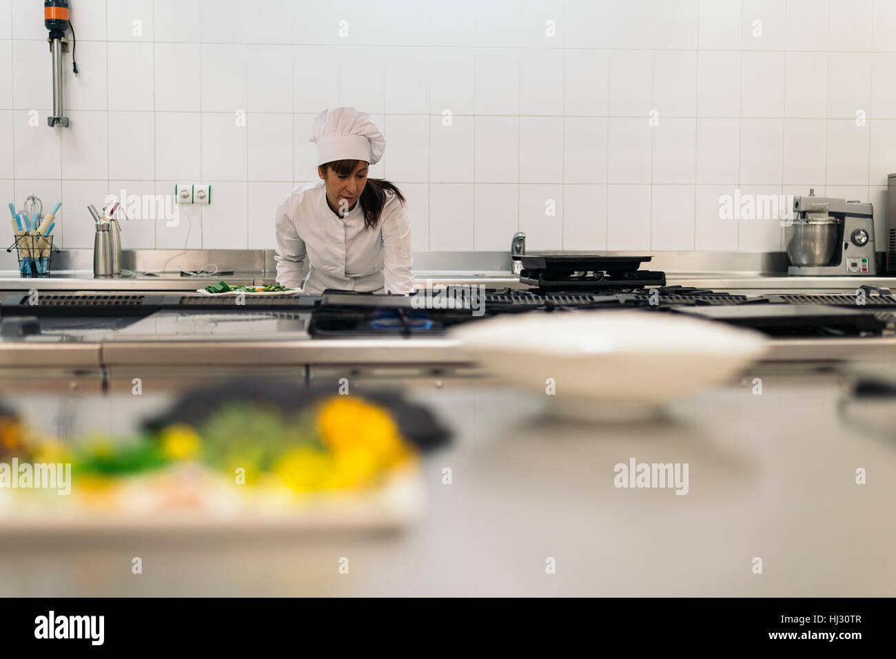 Pretty professional chef cooking in a kitchen Stock Photo - Alamy