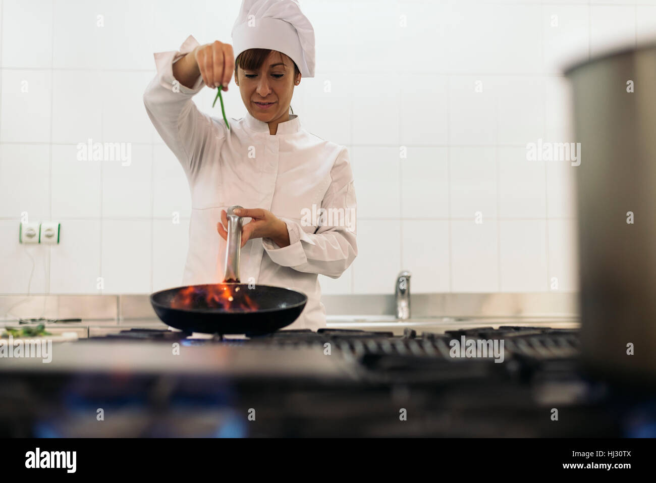Pretty professional chef cooking in a kitchen Stock Photo - Alamy