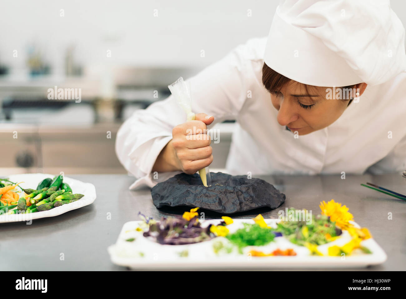Pretty professional chef cooking in a kitchen Stock Photo - Alamy