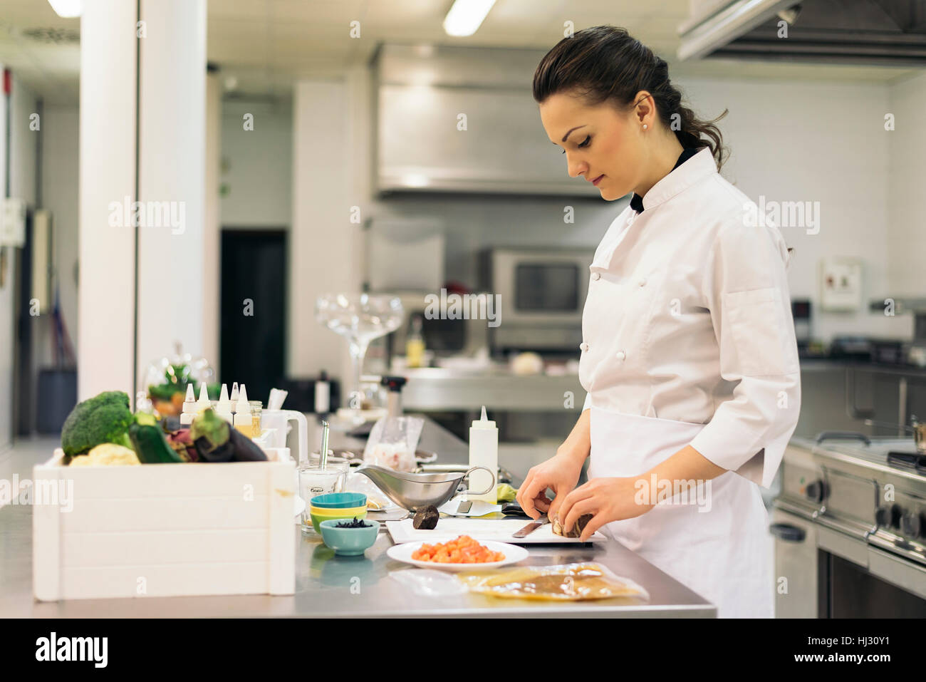 Pretty professional chef cooking in a kitchen Stock Photo - Alamy