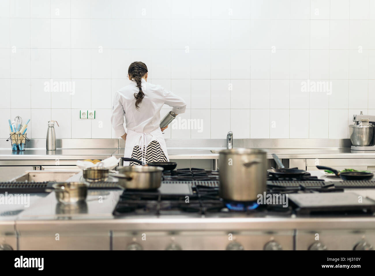 Pretty professional chef cooking in a kitchen Stock Photo - Alamy