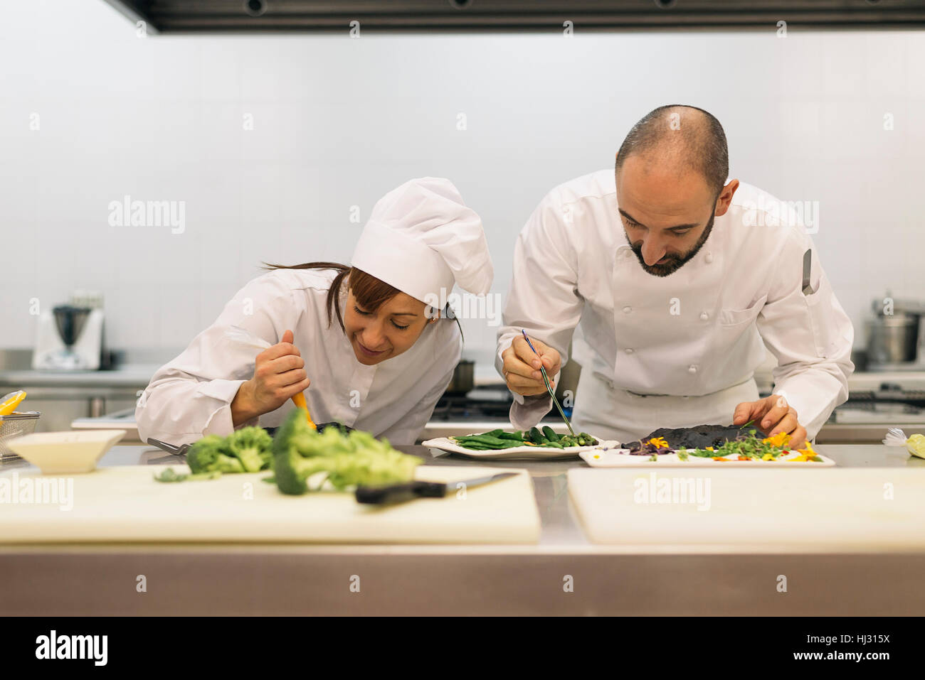 Two professionals chefs cooking together in a kitchen Stock Photo - Alamy