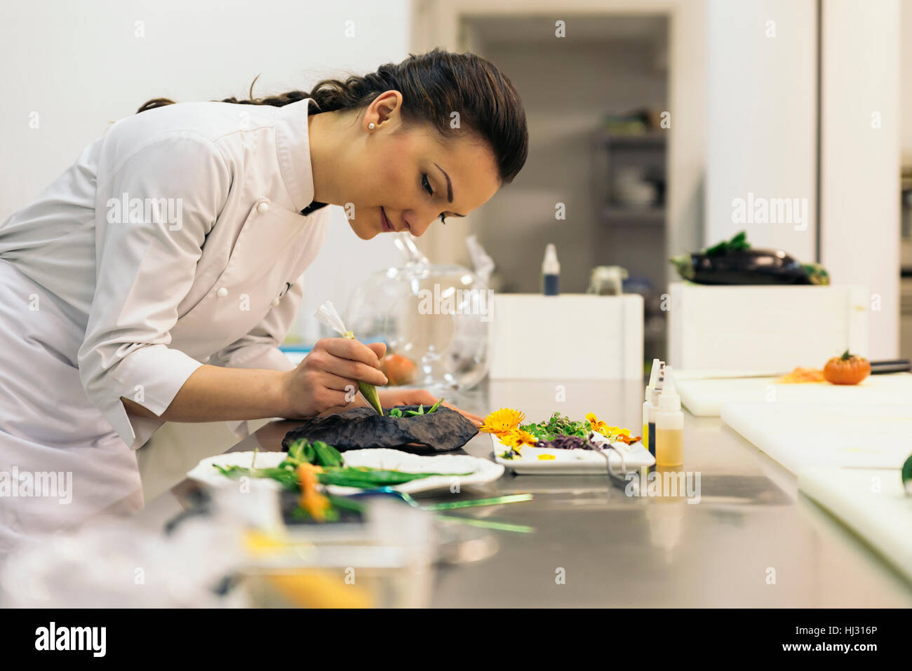 Pretty professional chef cooking in a kitchen Stock Photo - Alamy