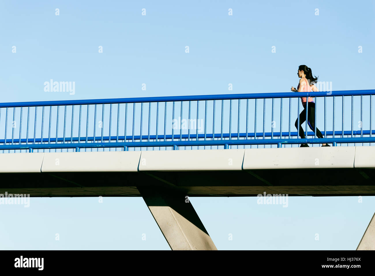 Young fitness woman runner running on city bridge. Sport Concept Stock ...