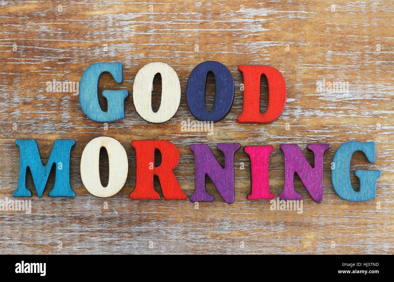 Good morning written with colorful letters on rustic wooden surface ...
