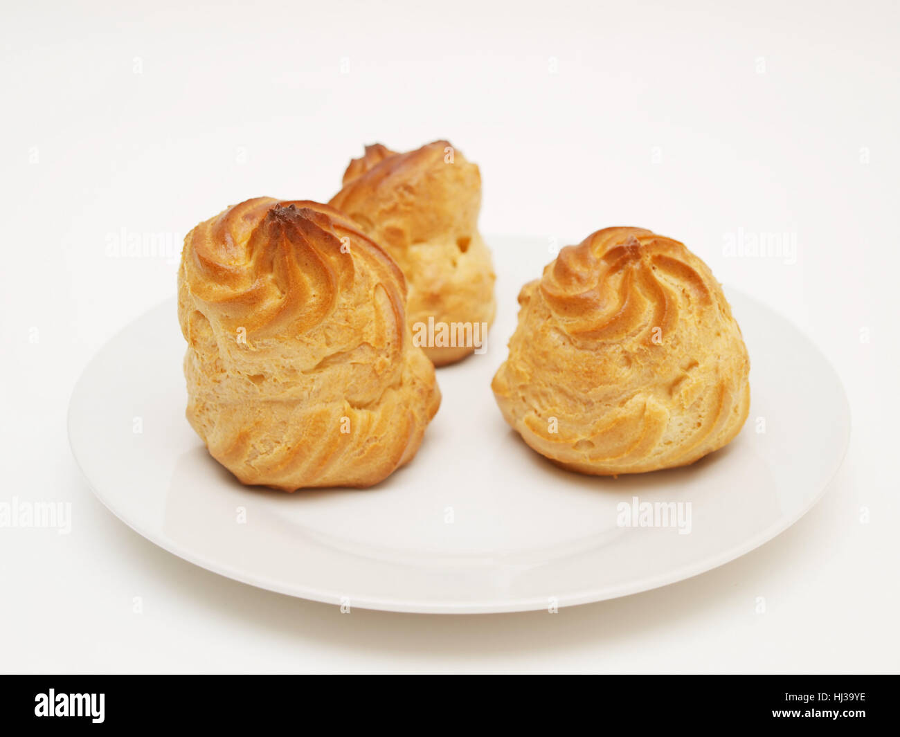 Choux pastry puffs, isolated on a plate, towards white background Stock ...