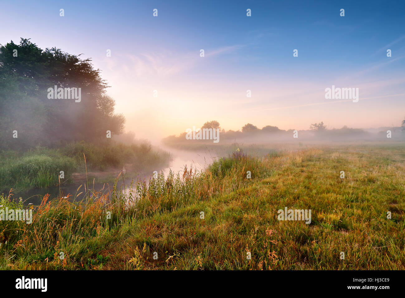 Summer misty sunrise on the river. Foggy river in the morning. Summer ...