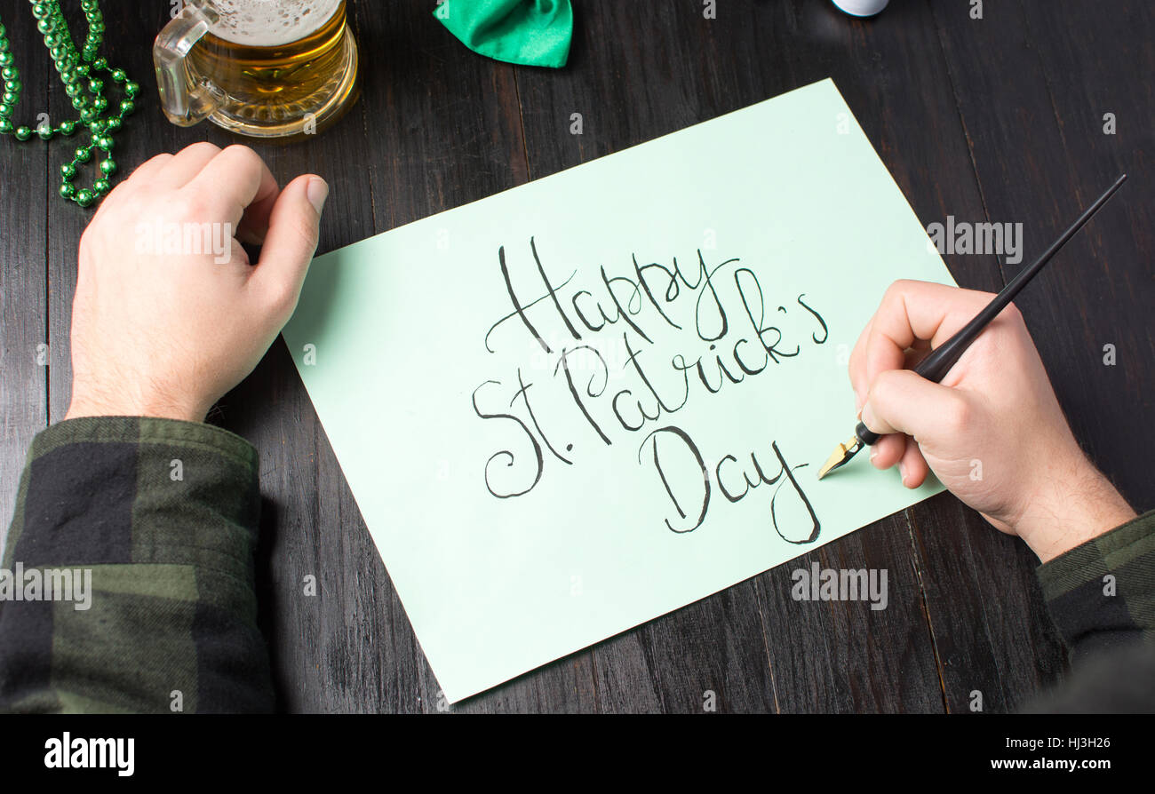 Male hands writing a Happy St Patrick day calligraphy card Stock Photo ...