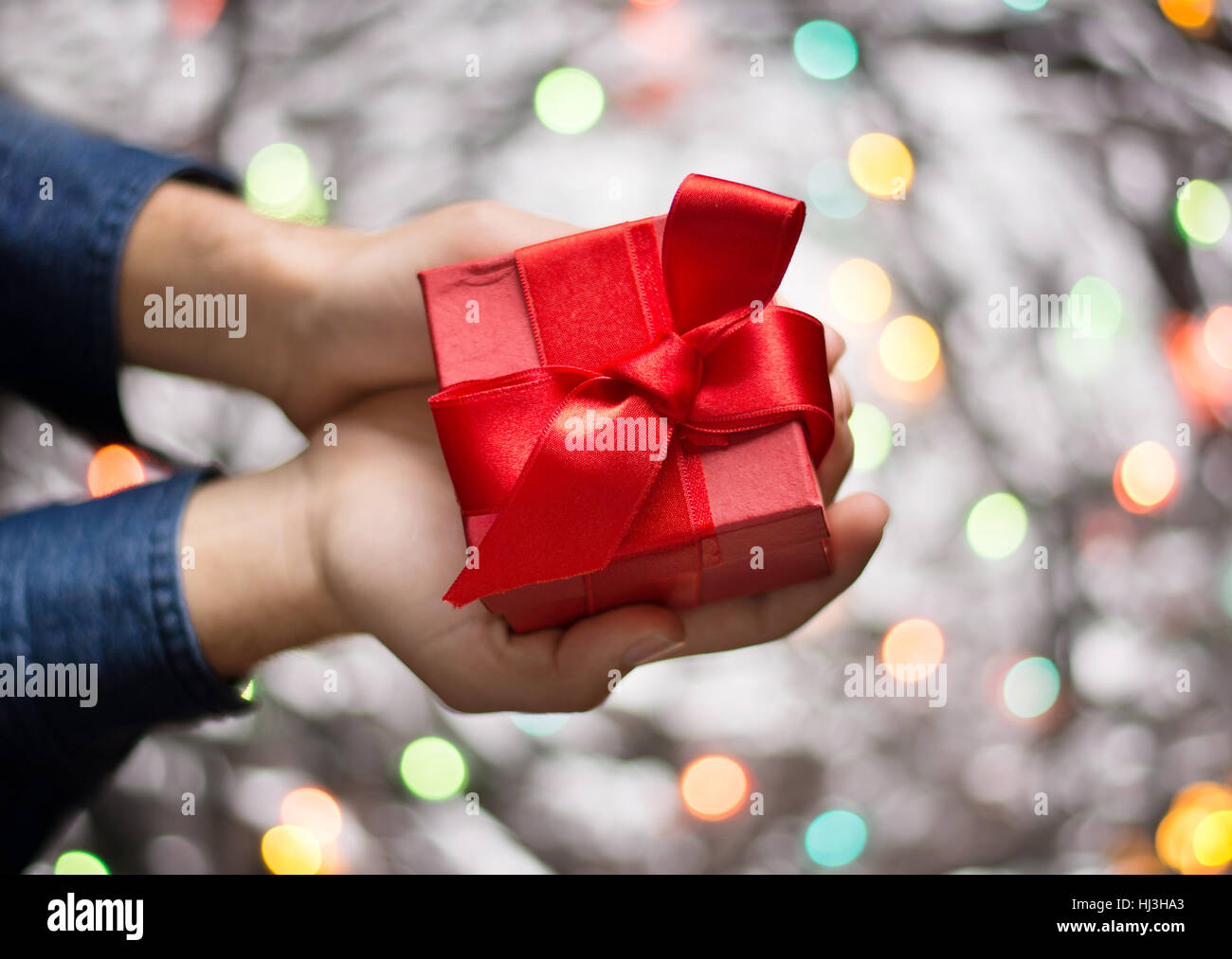 Male hands holding a red present with colorful background Stock Photo ...