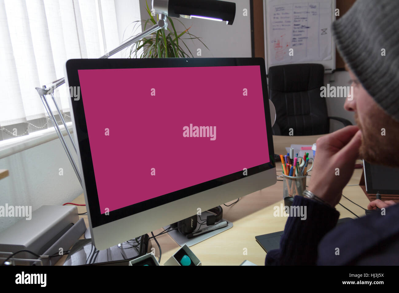 Creative man thinks up big ideas in front of very large digital desktop ...