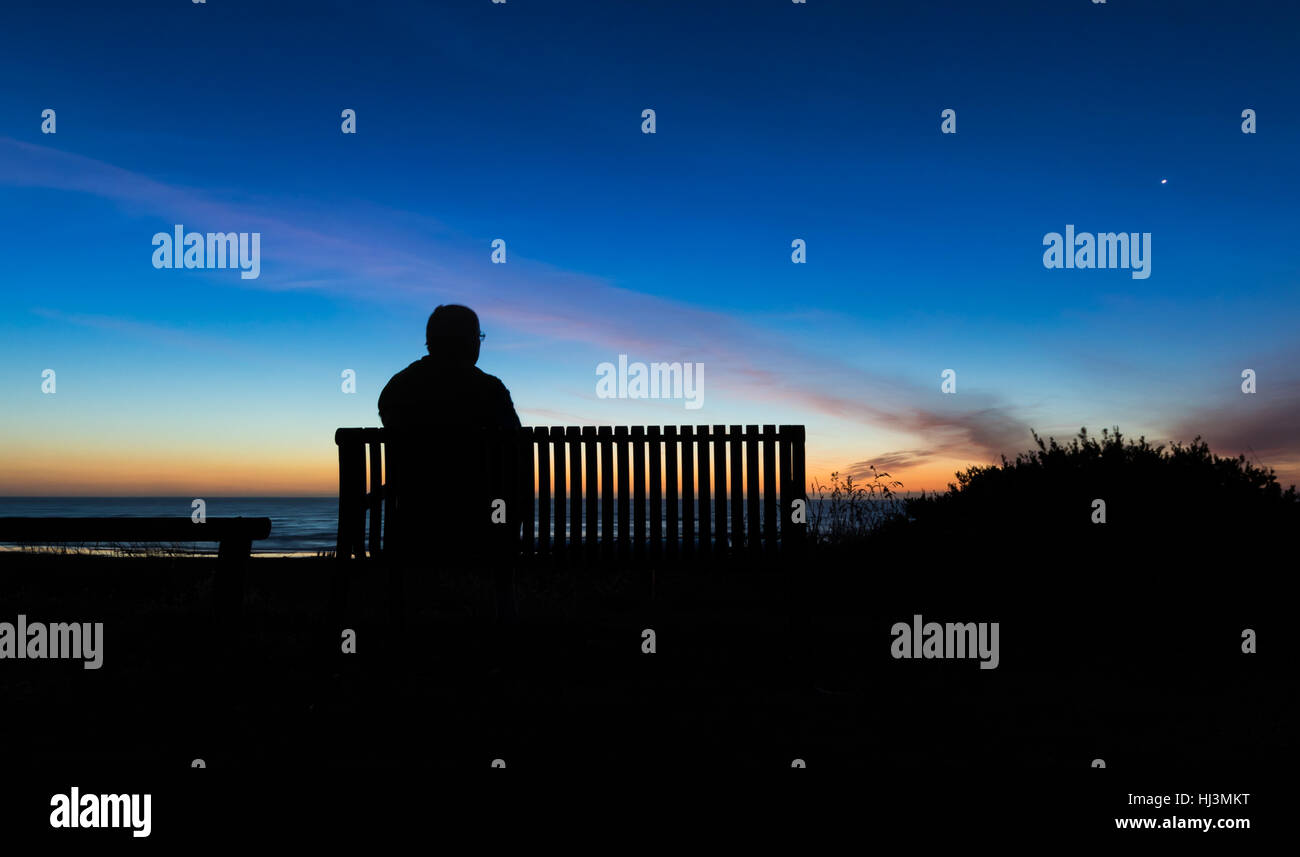 A Man siting on a beach side seat watch the first night sky star Stock ...