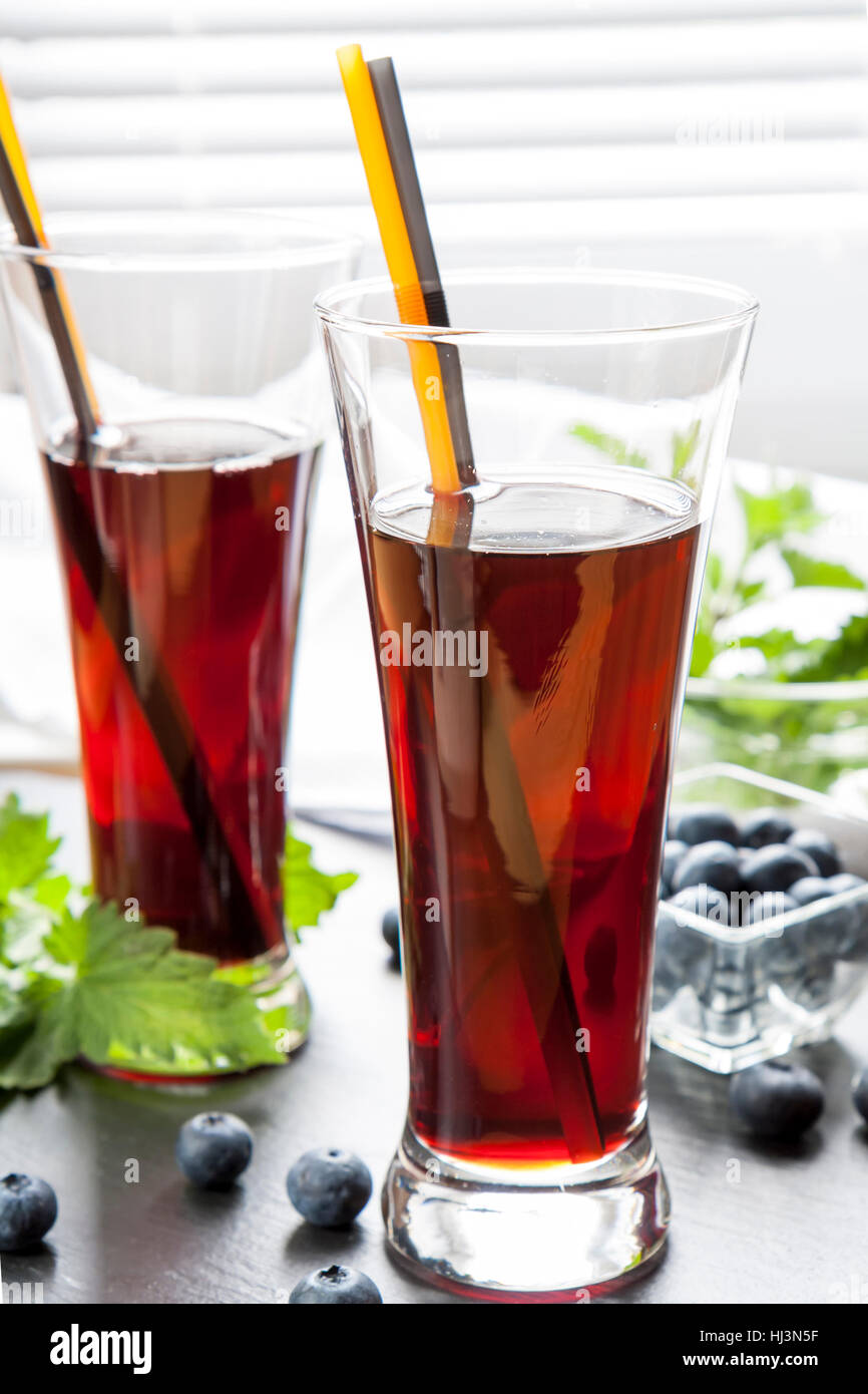 Glasses with fresh Black Currant juice. Bog blueberry and lemon balm on ...