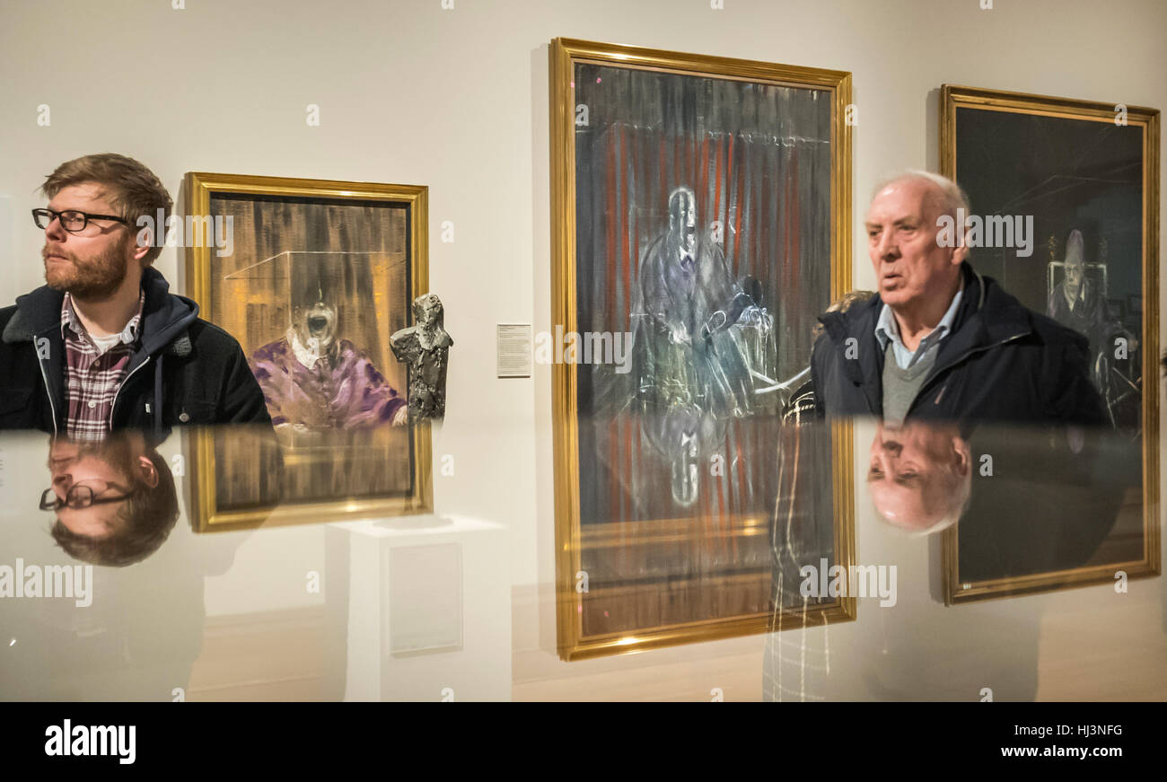 Members of the public, reflected in a display cabinet, view work from ...