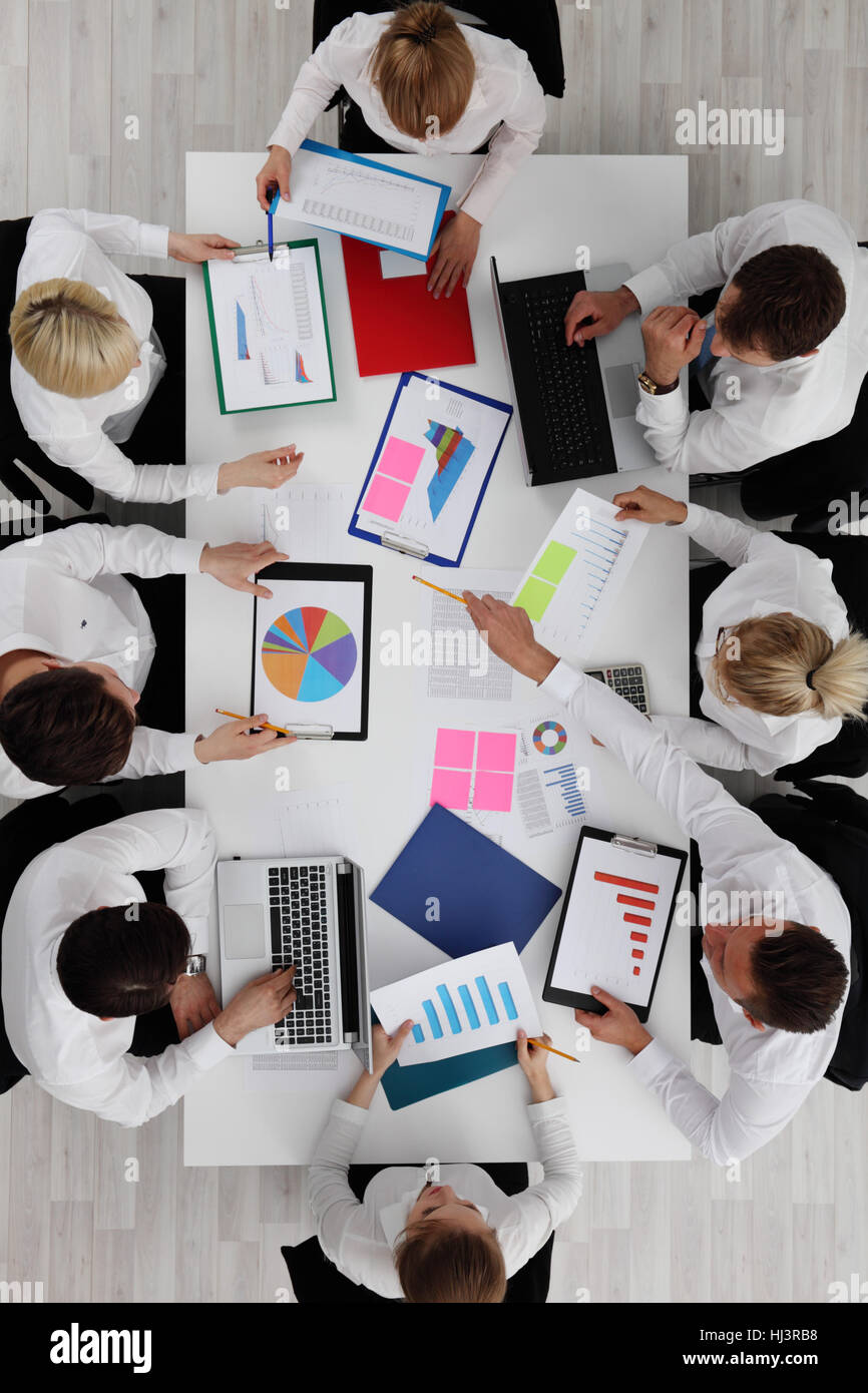 Team of business people working with graphs and diagrams sitting around ...