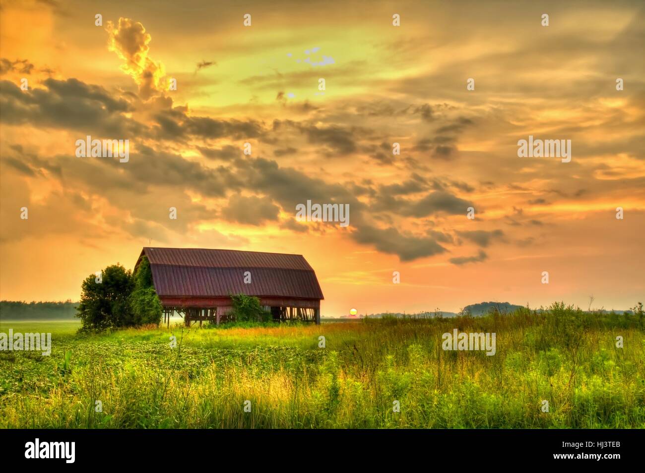 Wooden Barn Sunset. Rural sunset with an abandoned barn surrounded by ...