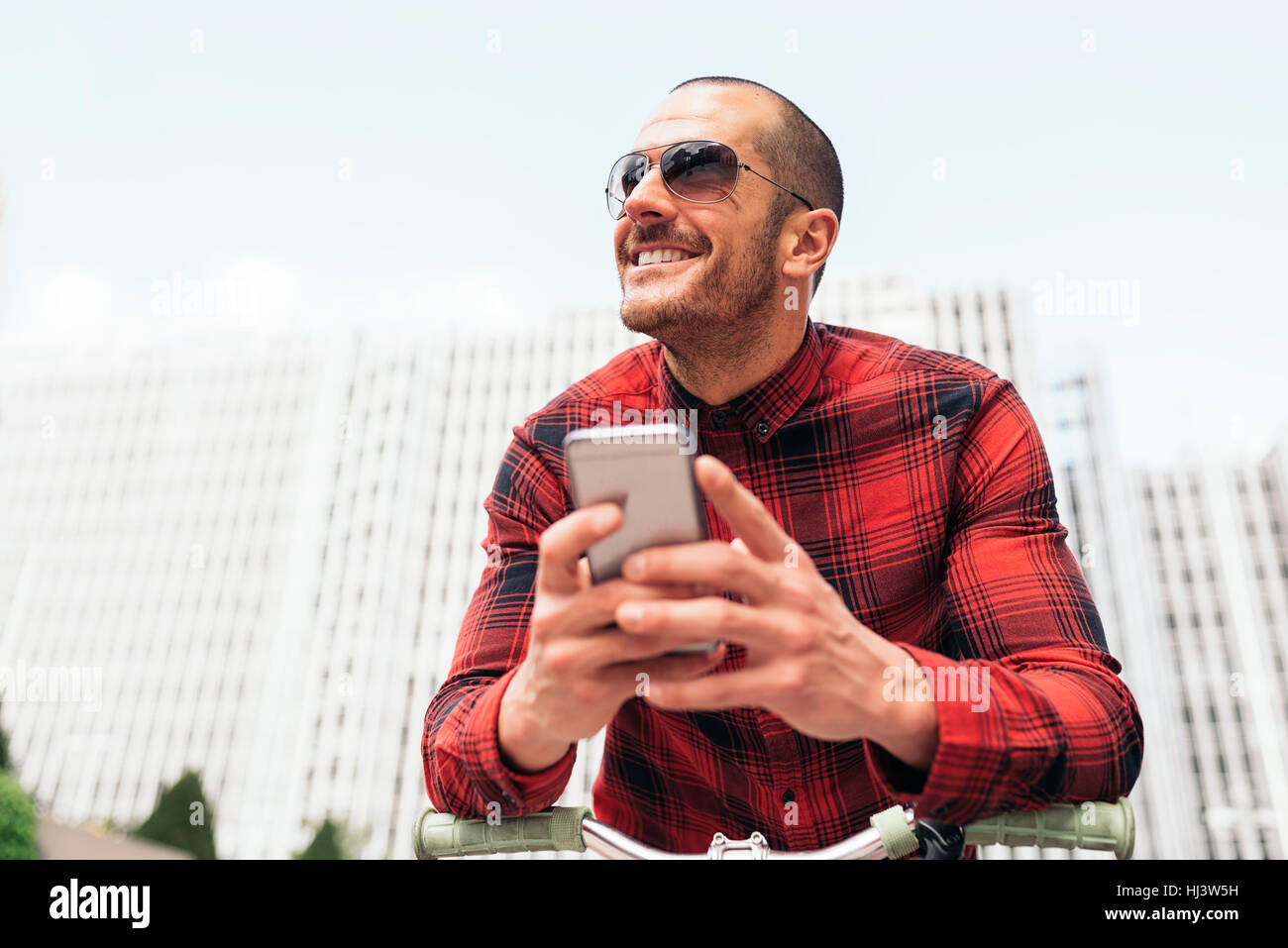 Handsome young man using his mobile in the street Stock Photo - Alamy