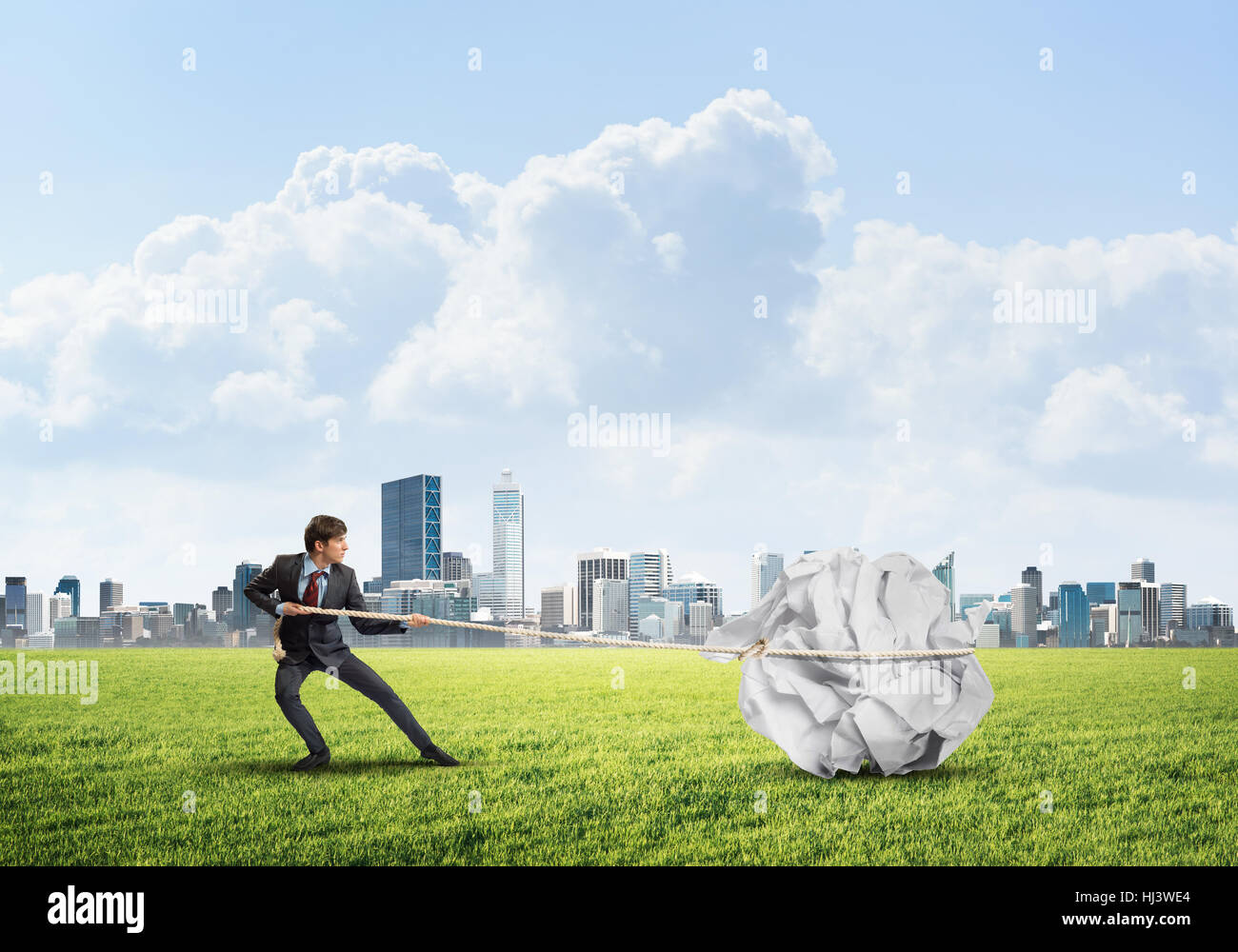 Man pulling with effort big crumpled ball of paper as creativity sign ...