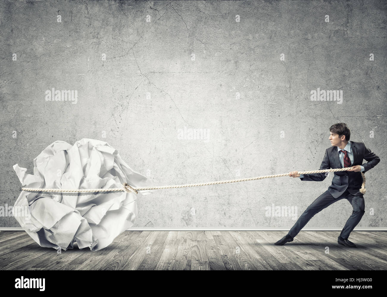 Man pulling with effort big crumpled ball of paper as creativity sign ...