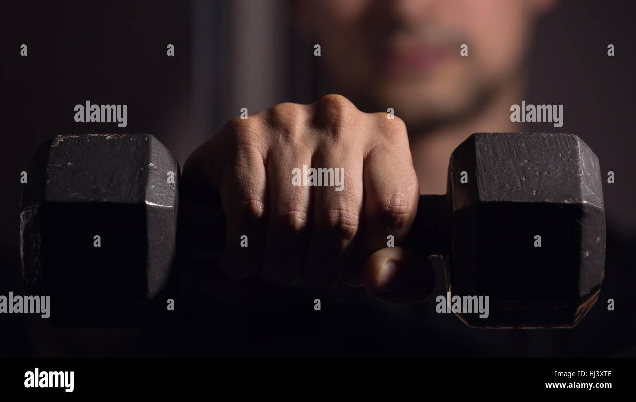 Young Man Holding Up Weight Towards Camera In The Gym Stock Photo - Alamy