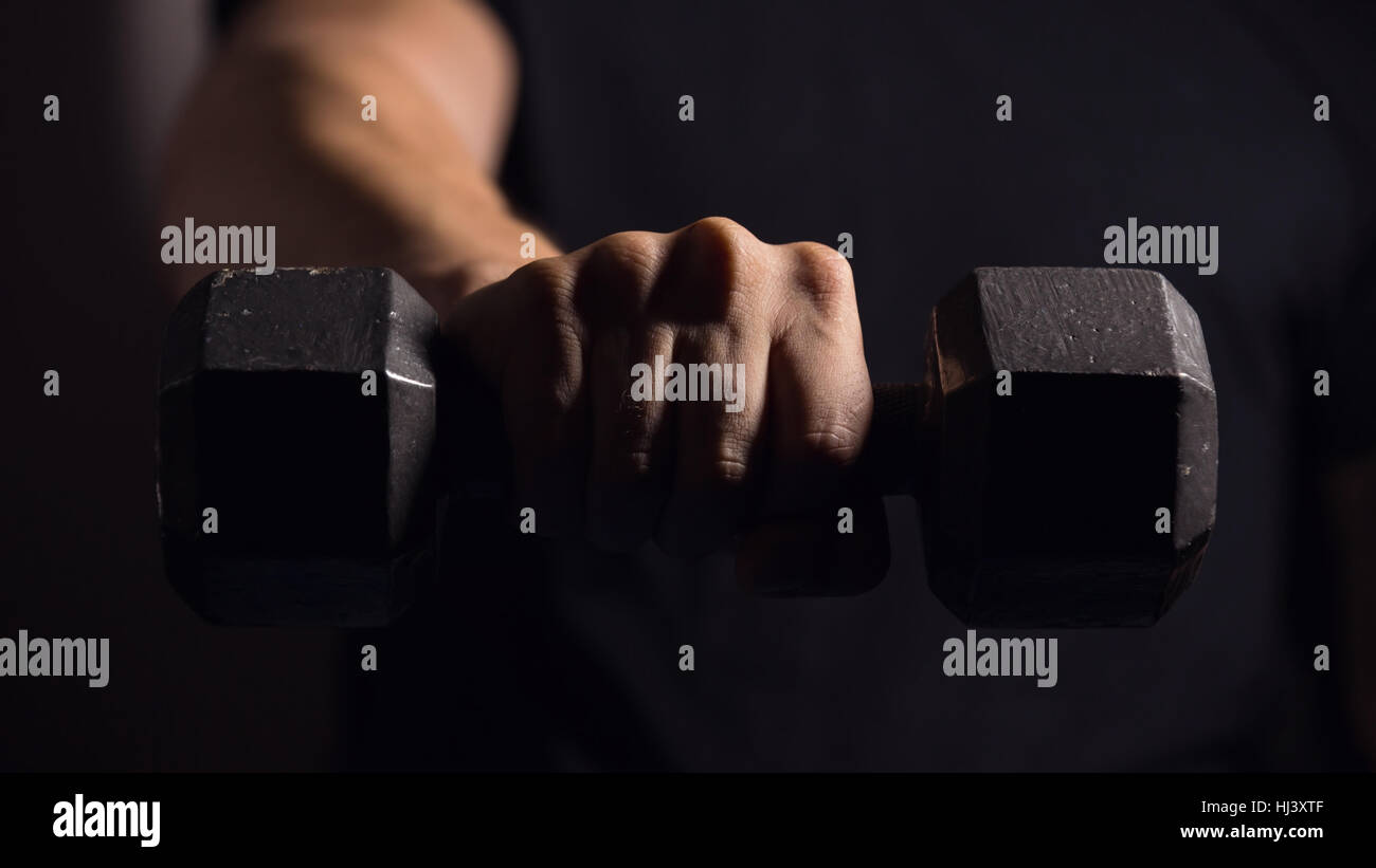 Young Man Holding Up Weight Towards Camera In The Gym Stock Photo - Alamy
