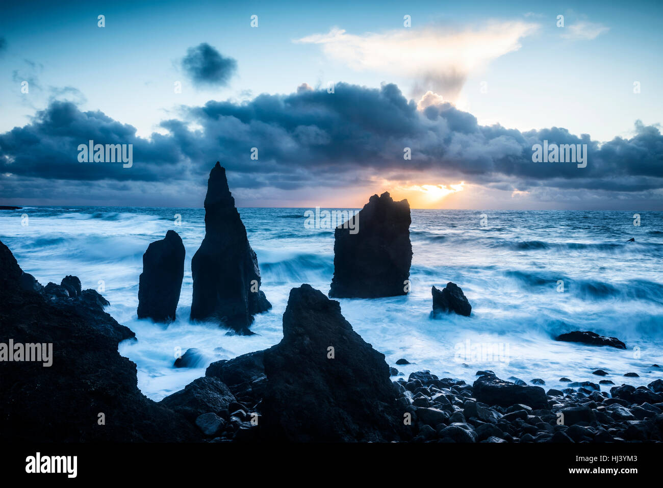 A remote beach in Iceland shows sharp rocky reefs protruding 20 feet ...