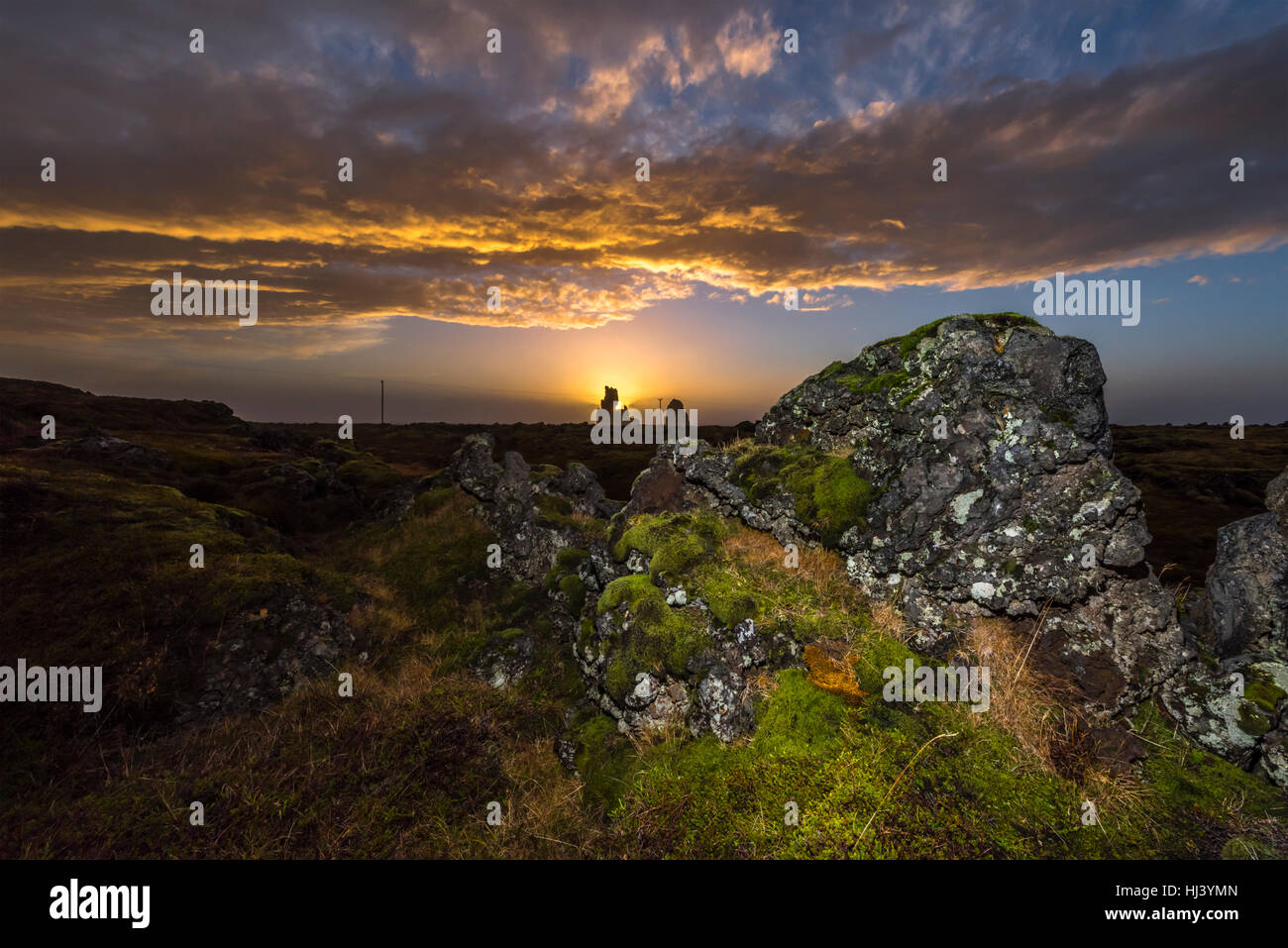Sunset over an oceanfront marsh shows a very moody, dark landscape ...