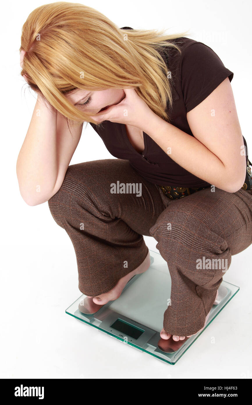 Woman checking her weight on a scale Stock Photo - Alamy