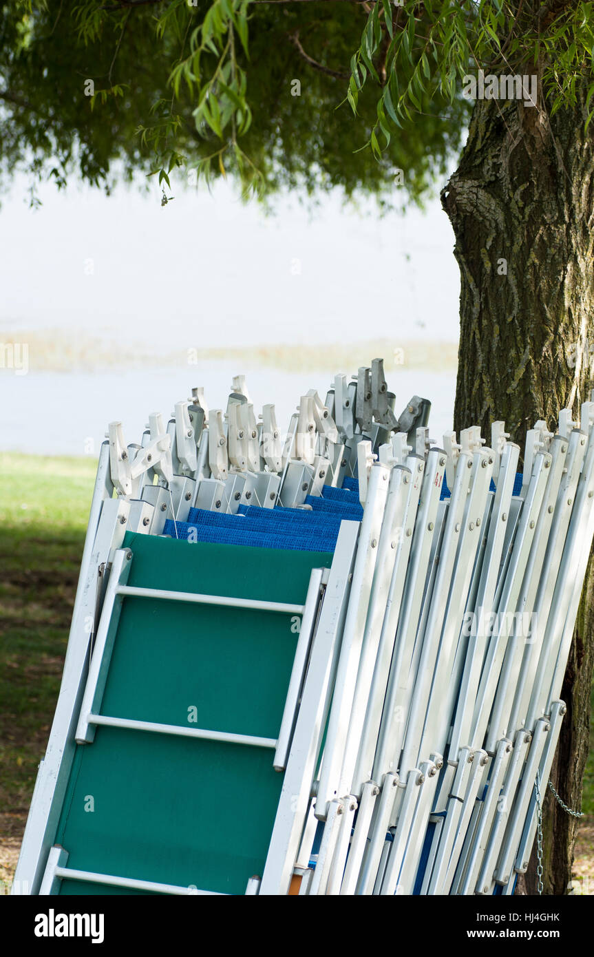empty sunbeds in line at the lake Stock Photo - Alamy