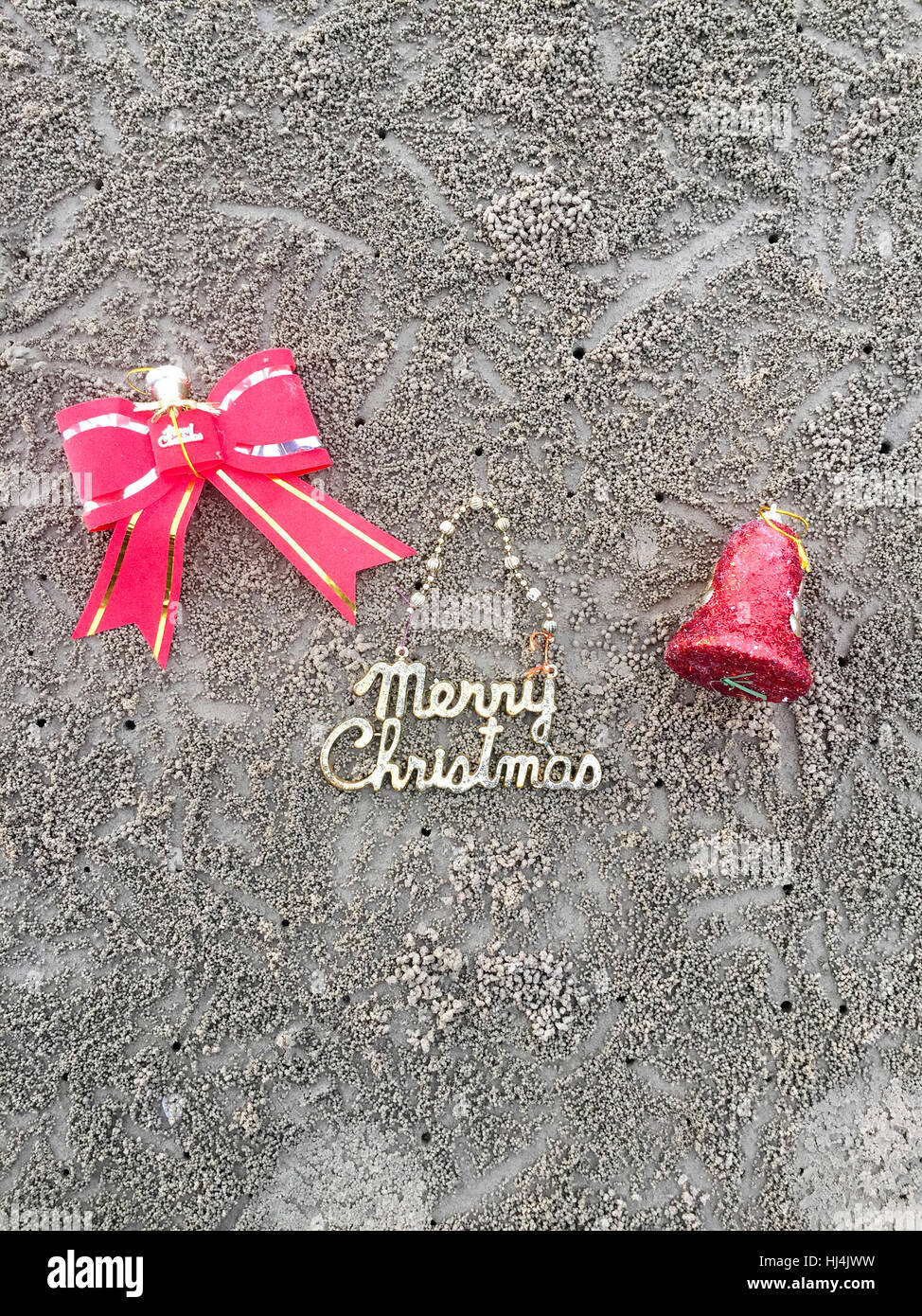Christmas chain, bell and ribbon for decoration on sandy beach Stock ...